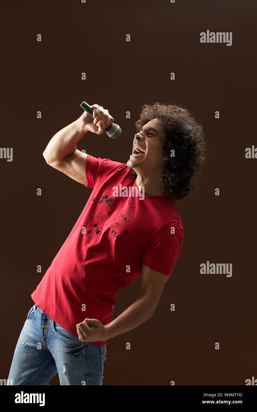 Man singing into microphone and smiling Stock Photo - Alamy
