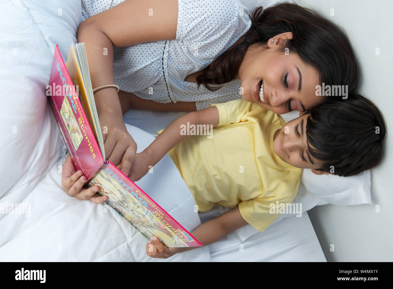 Woman teaching storybook to her son on bed Stock Photo - Alamy