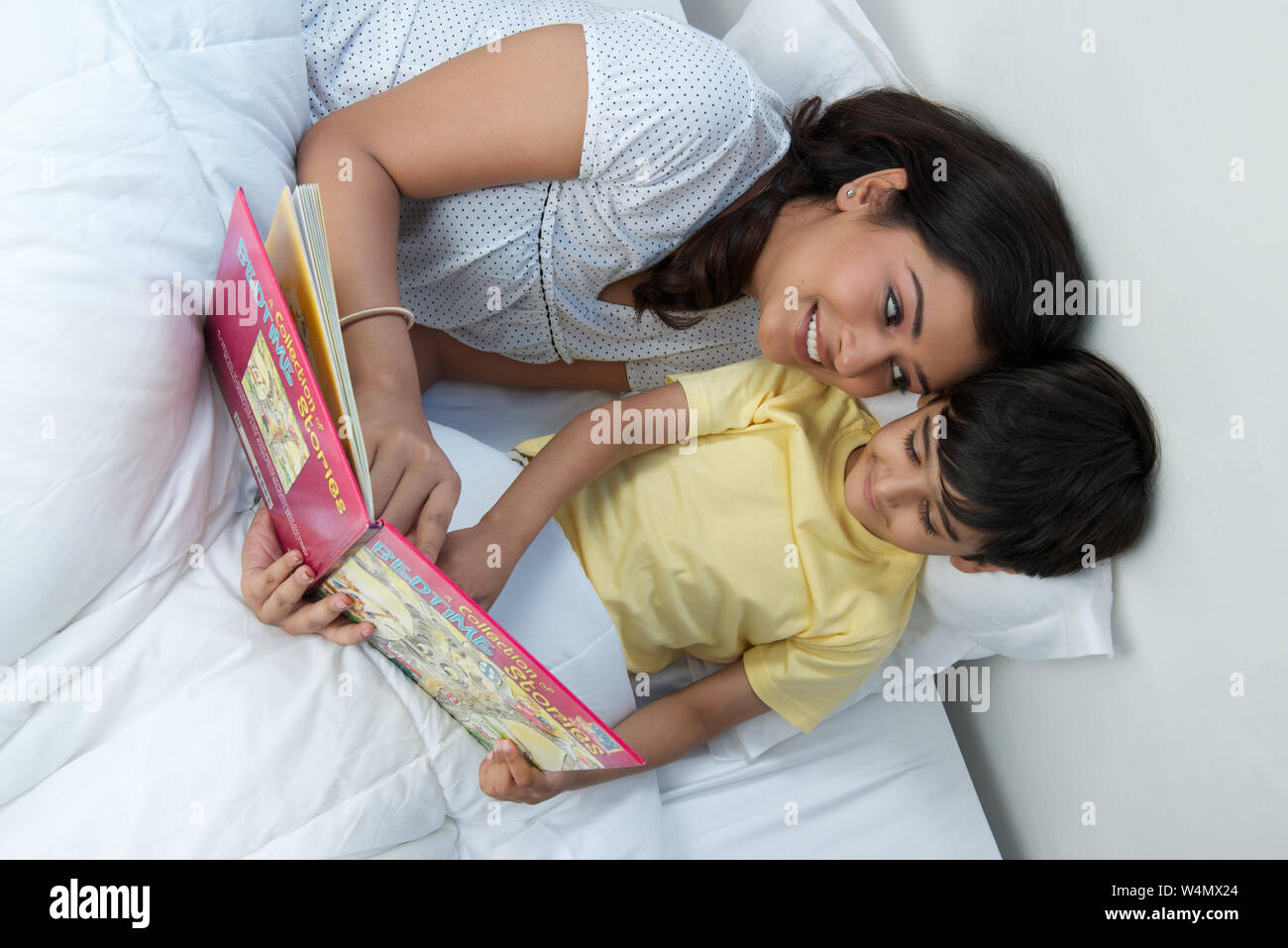 Woman teaching storybook to her son on bed Stock Photo - Alamy
