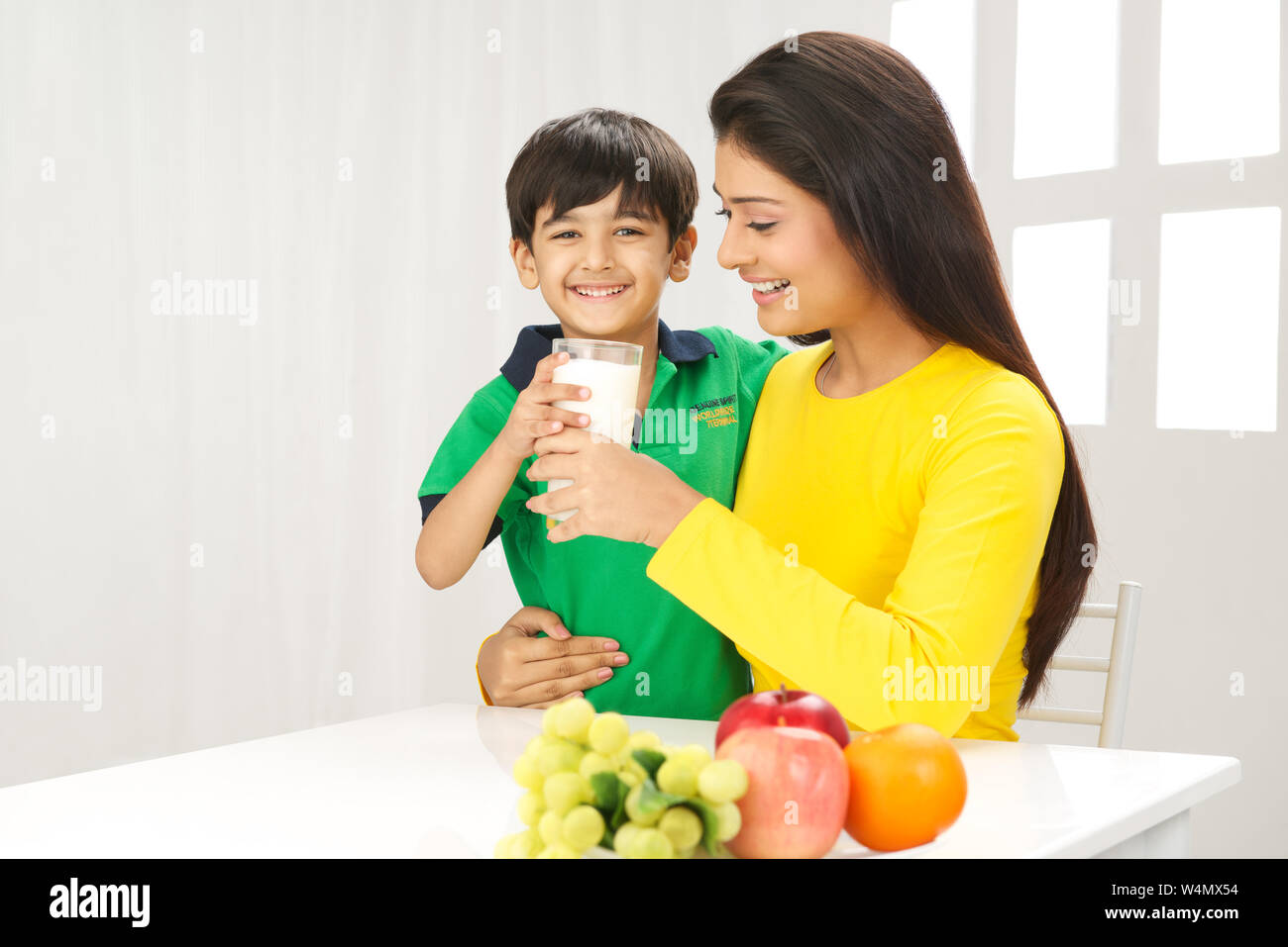 Woman giving milk to her son at home Stock Photo - Alamy