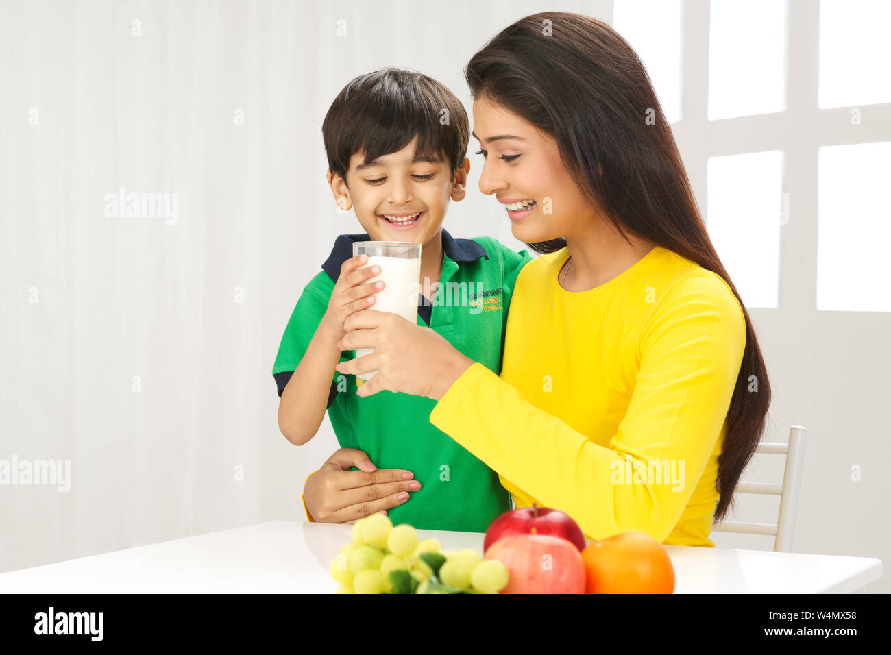 Woman giving milk to her son at home Stock Photo - Alamy