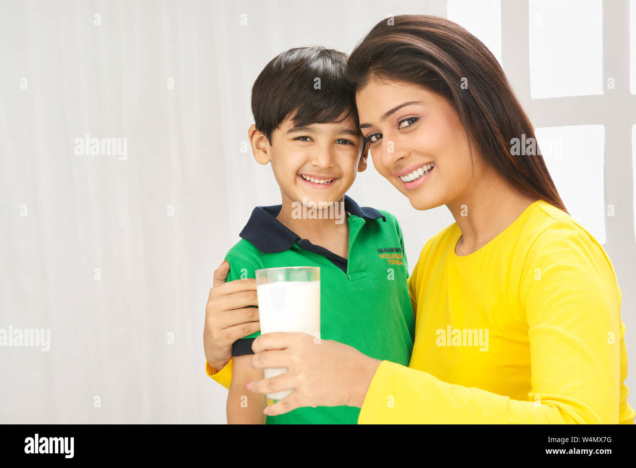 Woman giving milk to her son and smiling Stock Photo - Alamy