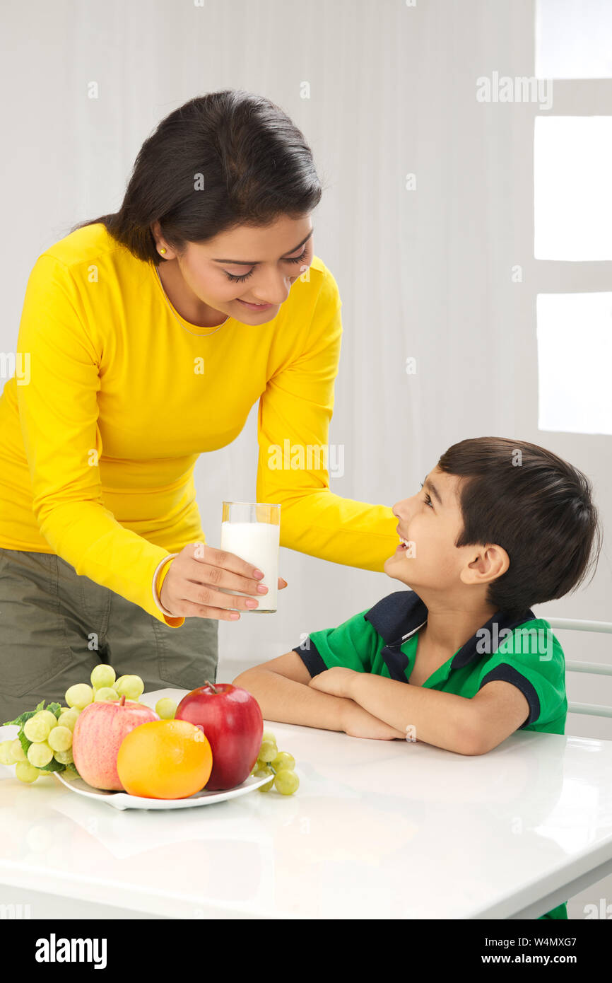 Woman giving milk to her son at home Stock Photo - Alamy