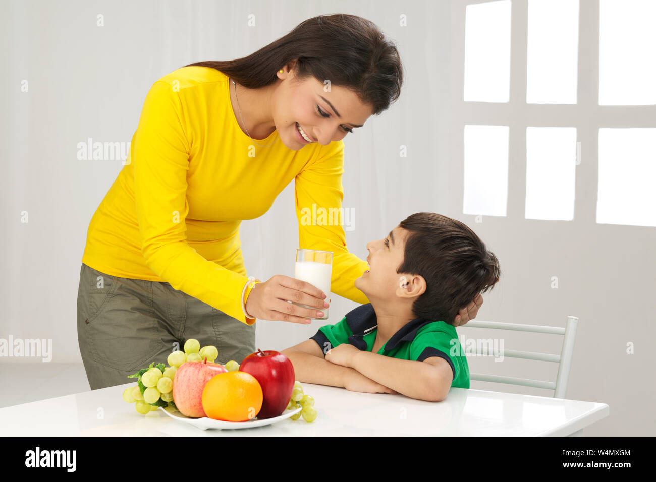 Woman giving milk to her son at home Stock Photo - Alamy