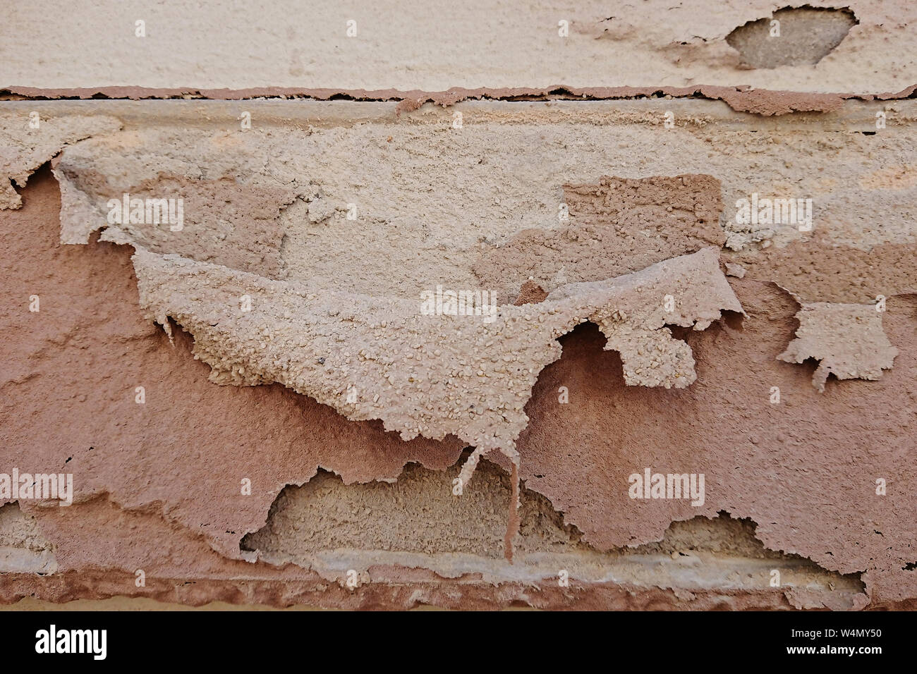 Closeup pieces of torn paint on brick wall on facade outdoor. Concept ...