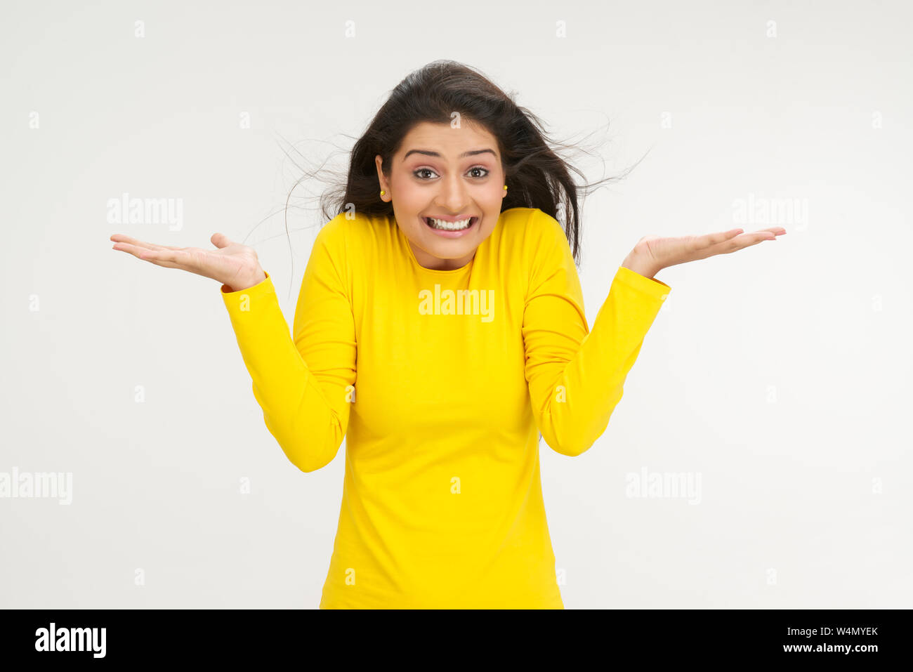 Woman shrugging shoulders and smiling Stock Photo - Alamy