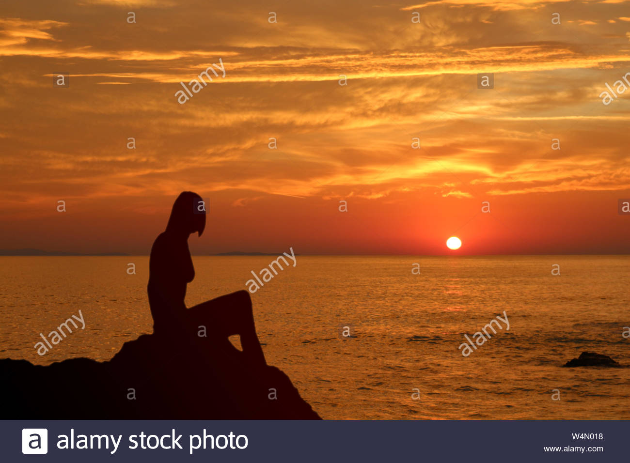 Young Woman Sitting On A Rock Stock Photos & Young Woman Sitting On A ...