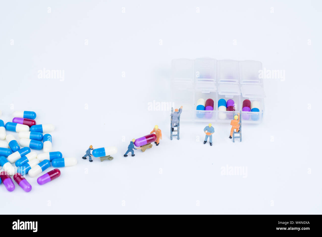 miniature people witn drug dialy container on white background Stock ...