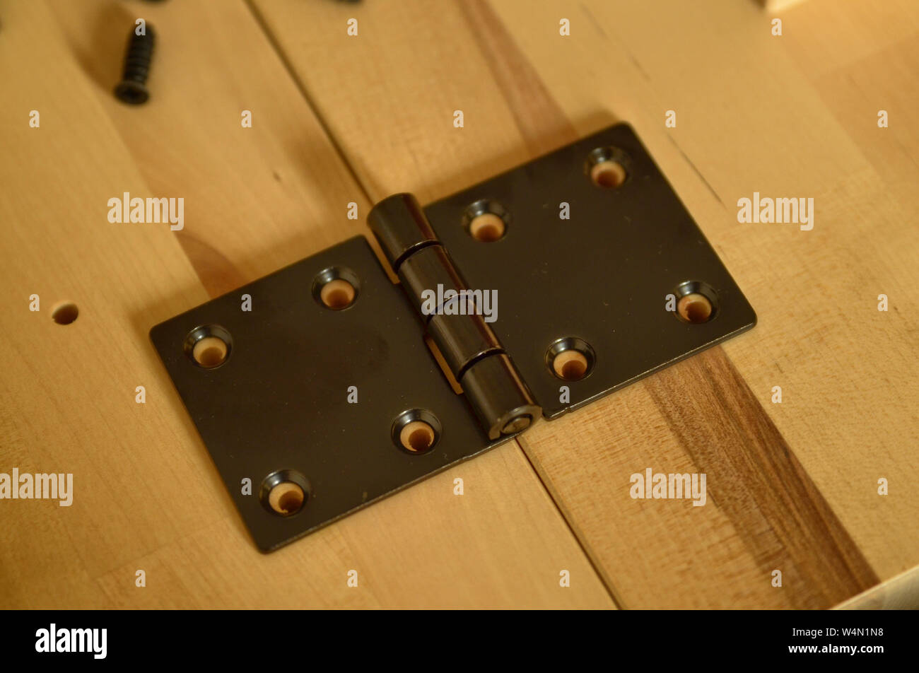 Black metal hinge on two light wooden boards Stock Photo - Alamy