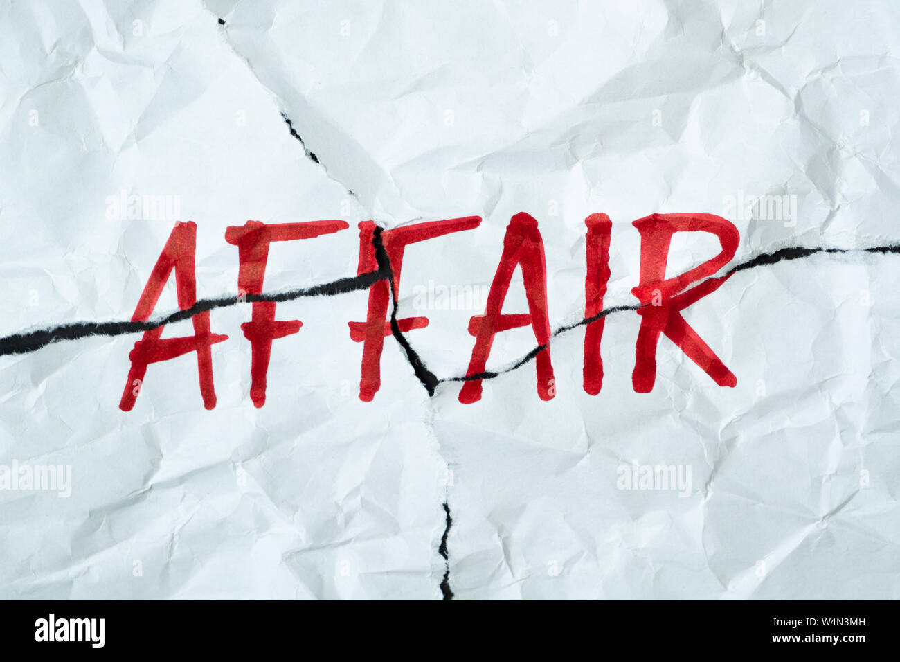 Word "affair" handwritten on crumpled torn paper, top view. Sign ...