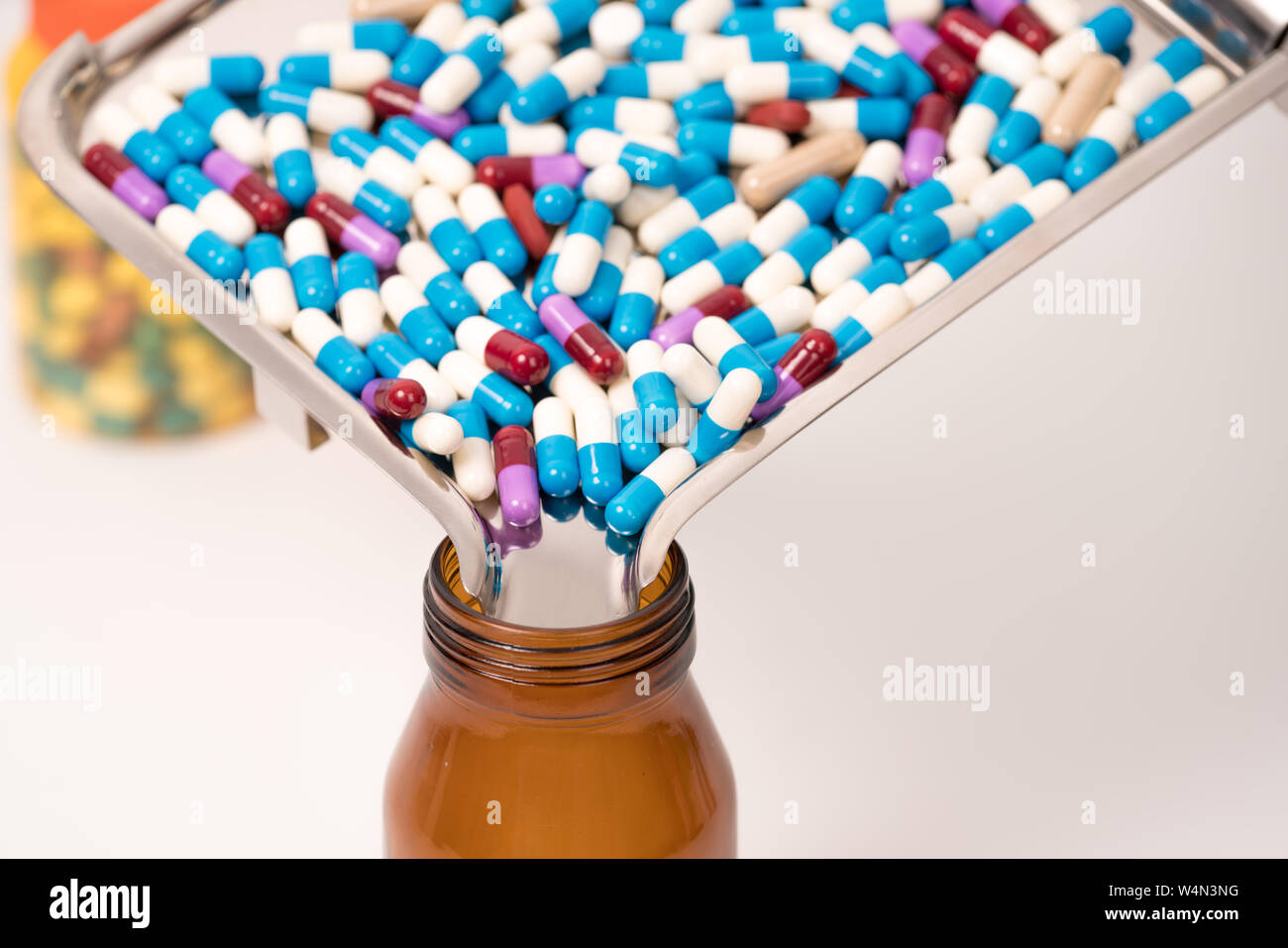 colorful medical drug capsule falling from medicaltray to browb bottle ...