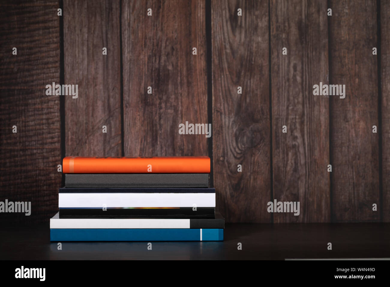 Books stacked against a wooden panel background with blank areas for ...
