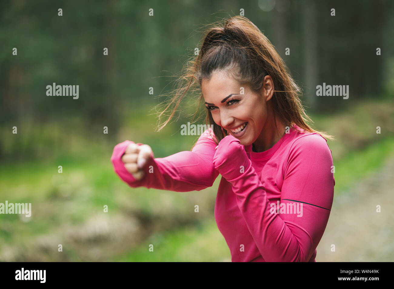 Young female runner warming up before running and having fun at morning ...