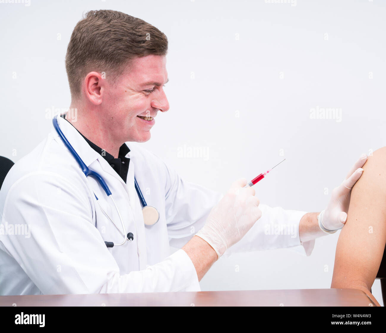 Nurse giving male patient injection hi-res stock photography and images ...