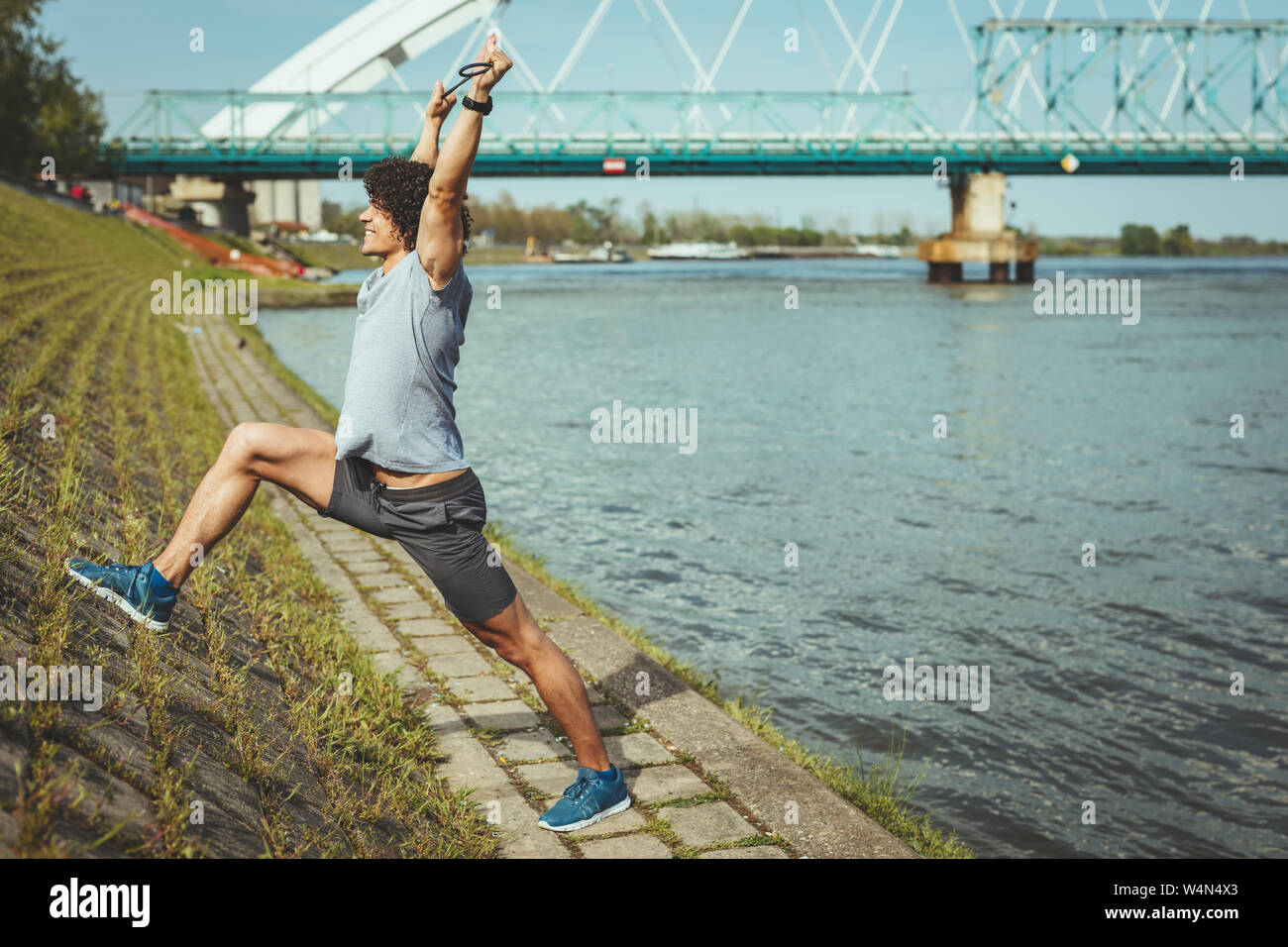 Fit muscular young man doing core stretching exercise with resistance ...
