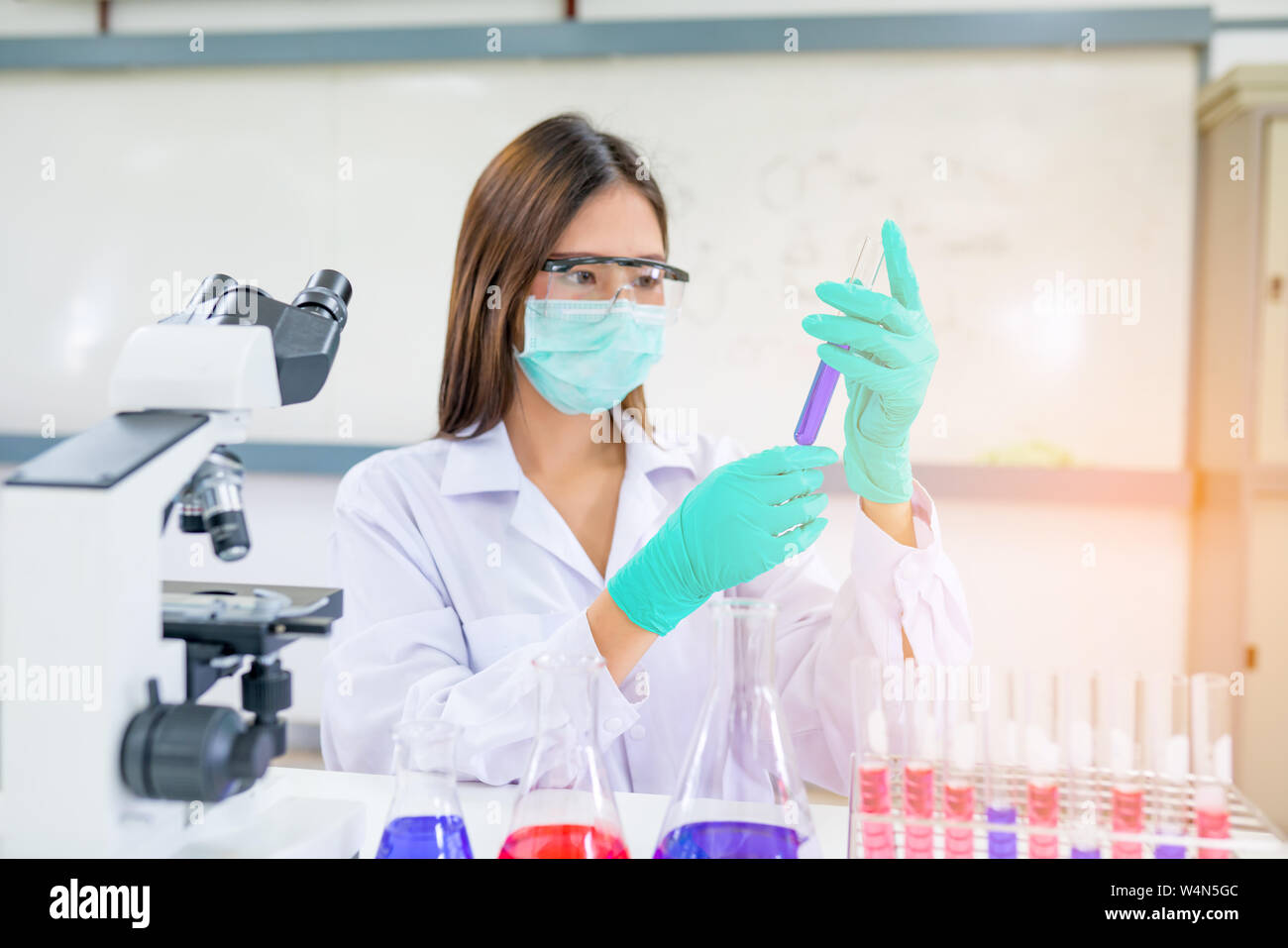 Doctor woman or chemist working with microscope in laboratory room ...