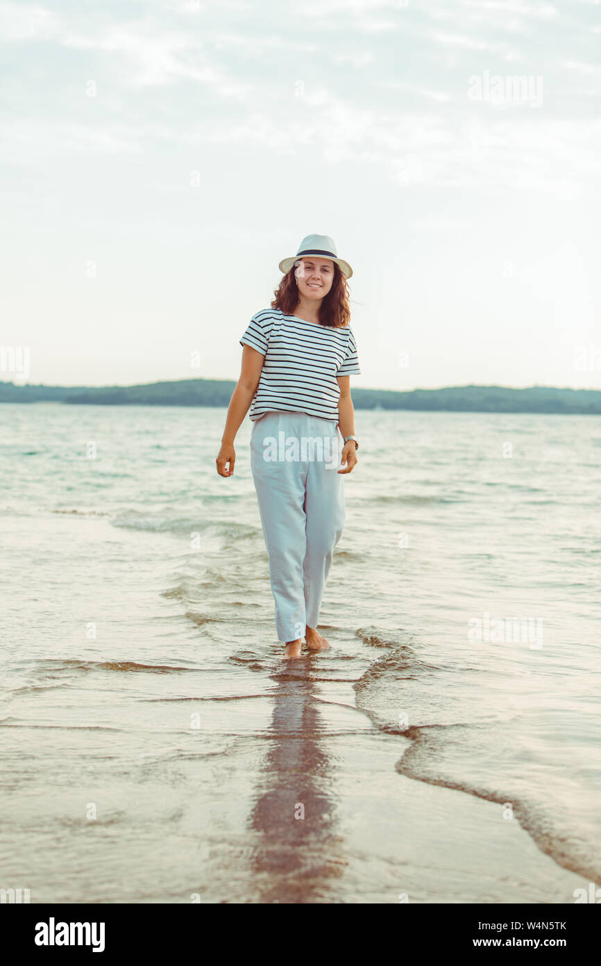 woman in white clothes walking by sea beach summer time Stock Photo - Alamy