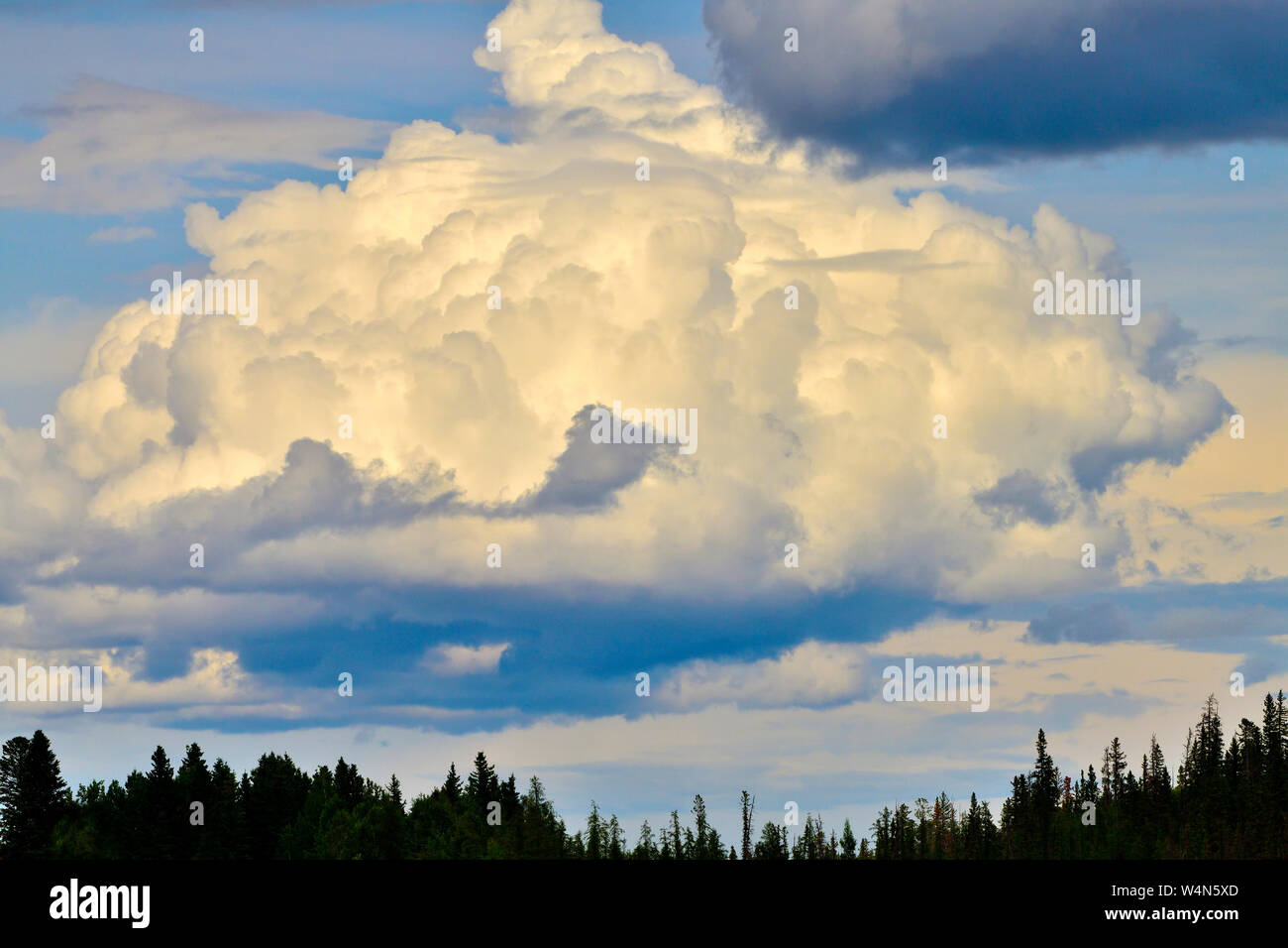 A storm cloud floating through a blue sky in rural Alberta Canada Stock ...