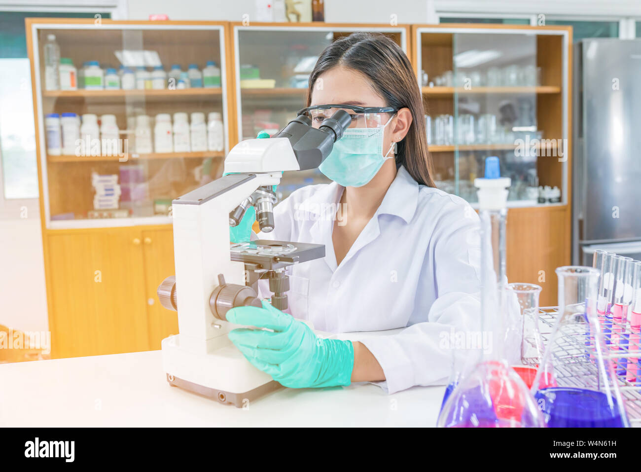 Doctor woman or chemist working with microscope in laboratory room ...