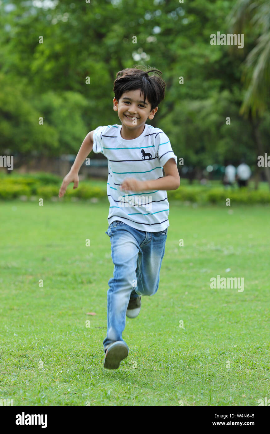Boy running in a lawn Stock Photo - Alamy