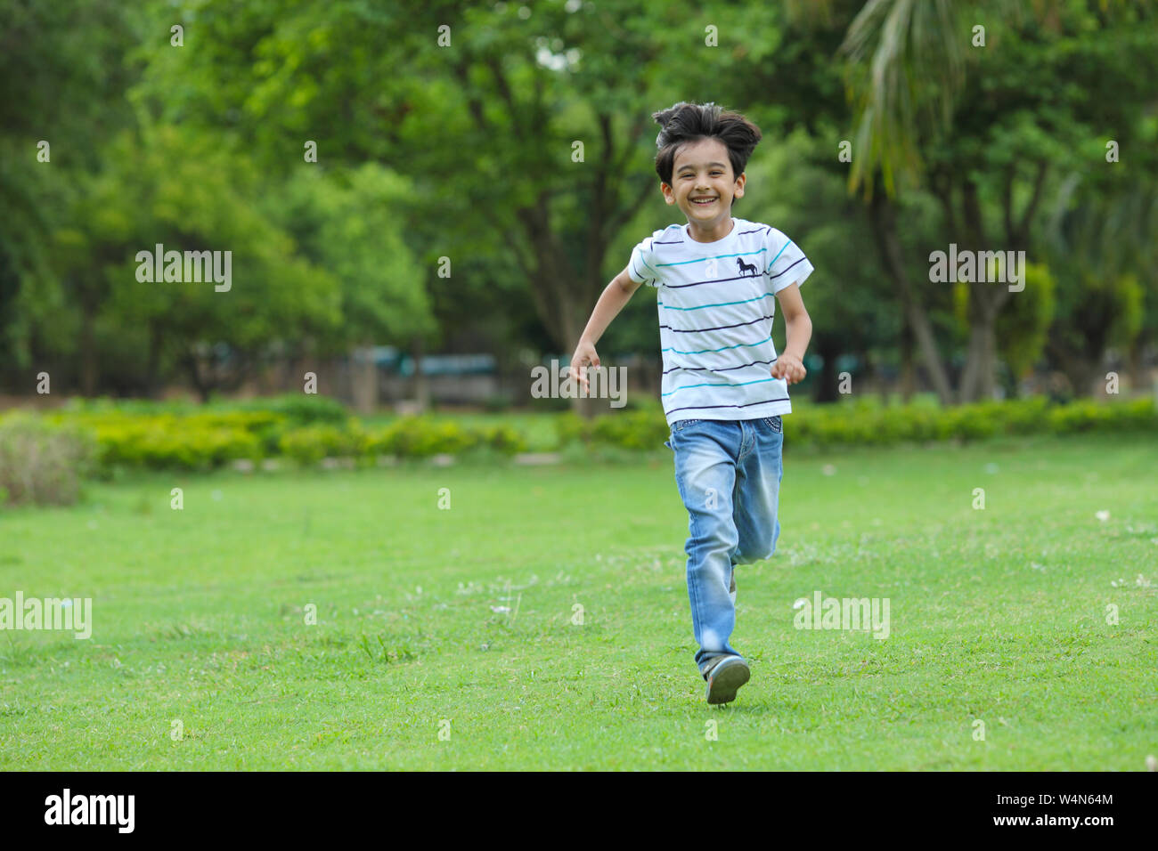Boy running in a lawn Stock Photo - Alamy