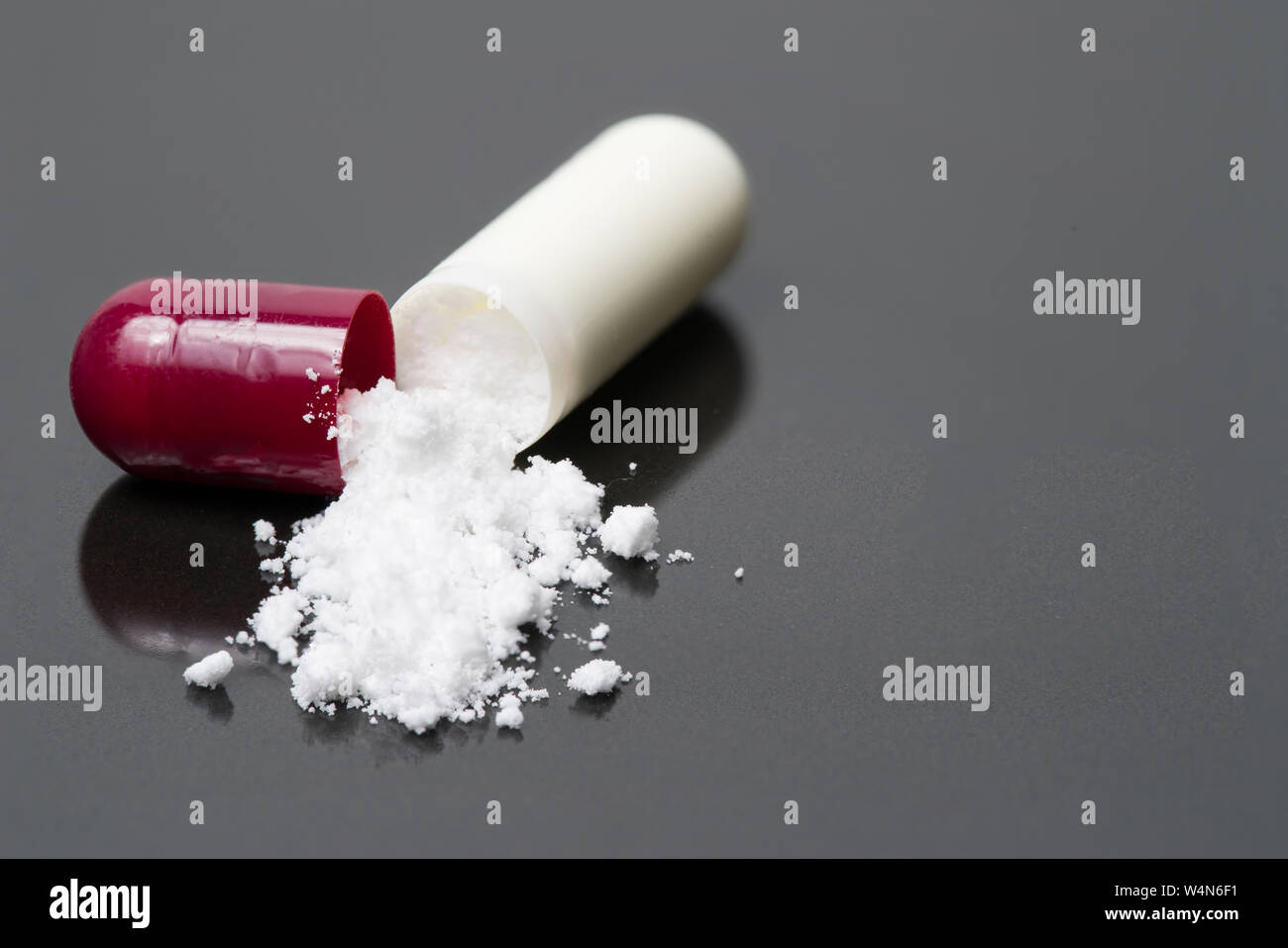 medical drug capsule and powder on black background Stock Photo - Alamy