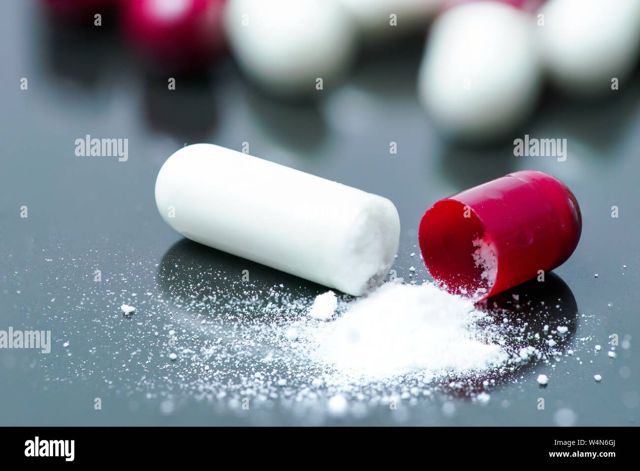 medical drug capsule and powder on black background Stock Photo - Alamy