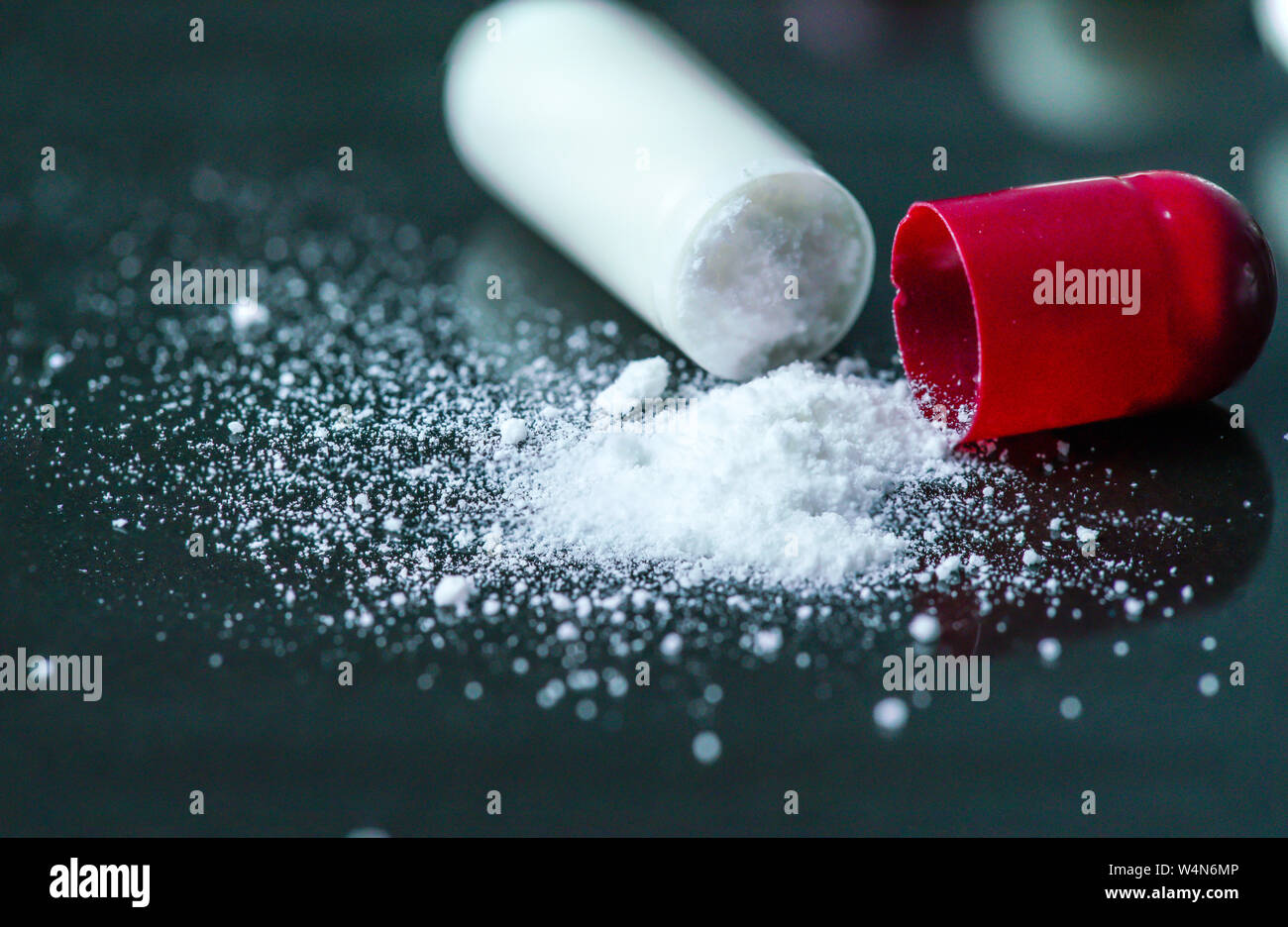 medical drug capsule and powder on black background Stock Photo - Alamy