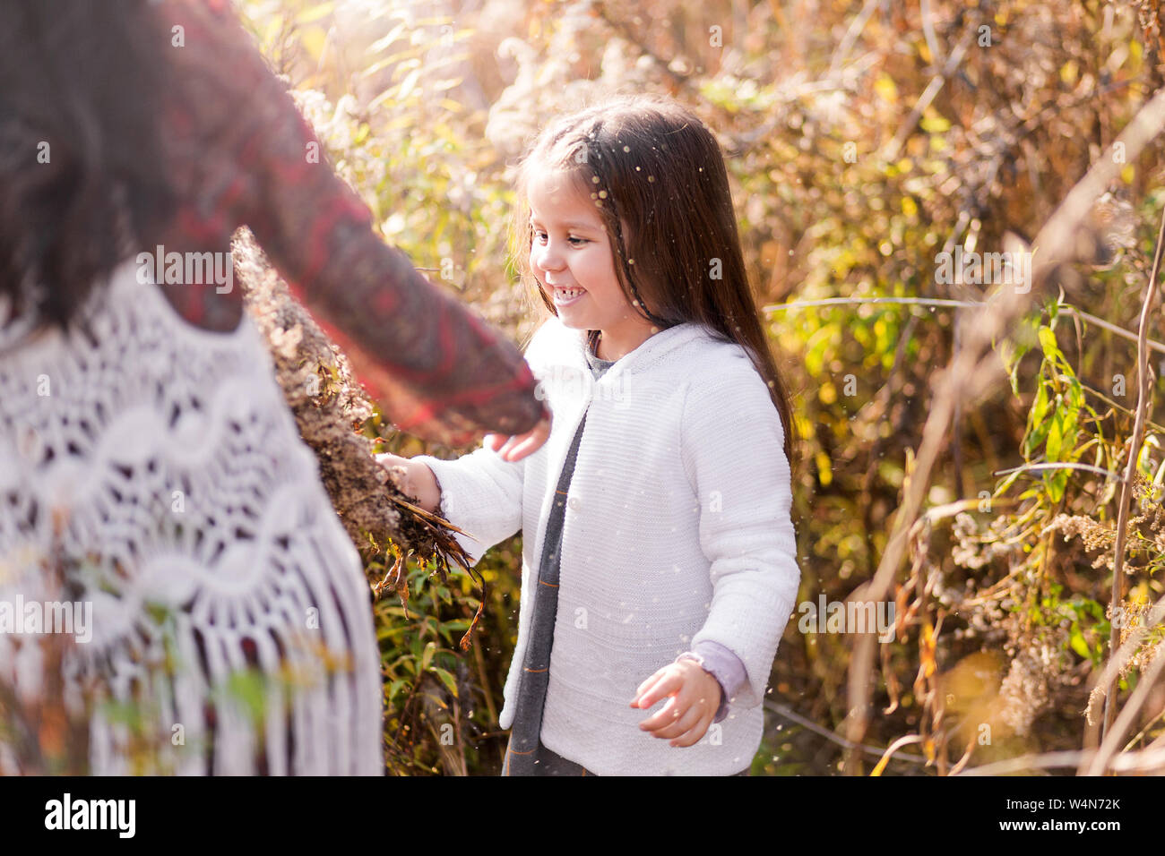 Photo of Happy little girl have fun with autumn yellow dry plants Stock ...