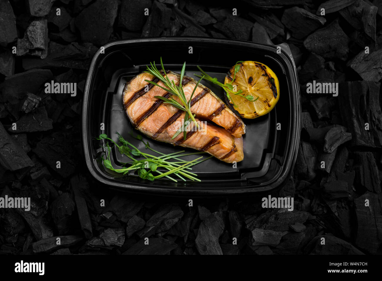 Top view of grill cooked fish in take away box on coal Stock Photo - Alamy