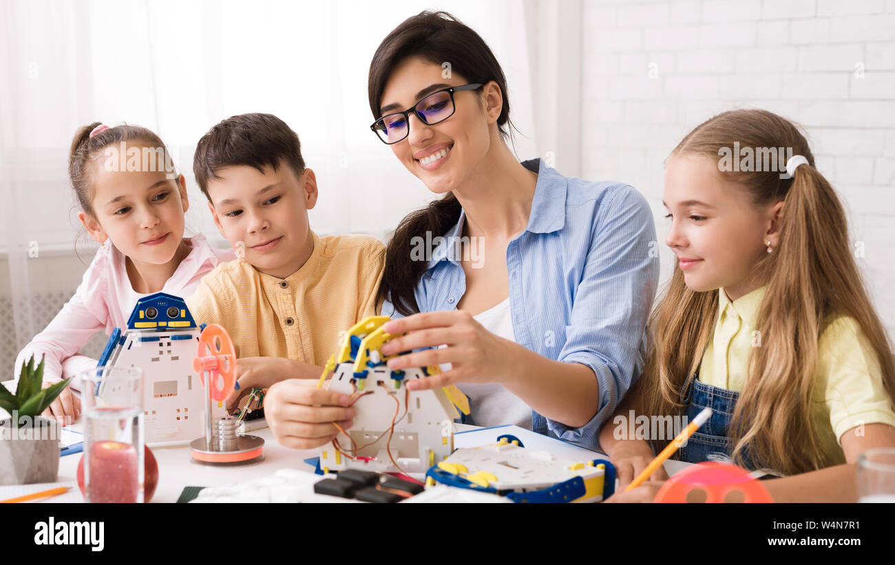 Stem education. Pupils creating robots with teacher Stock Photo - Alamy
