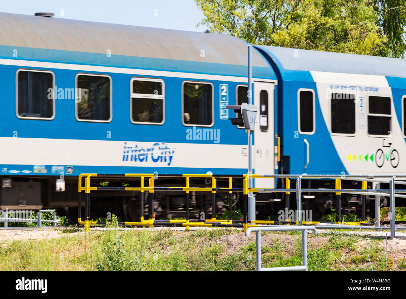 InterCity train passing level crossing for pedestrians at Lake Balaton ...