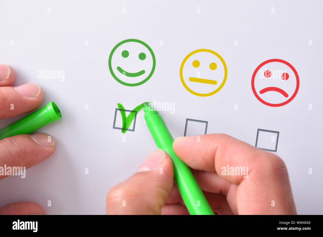 Hand marking a level of positive satisfaction represented with colored ...