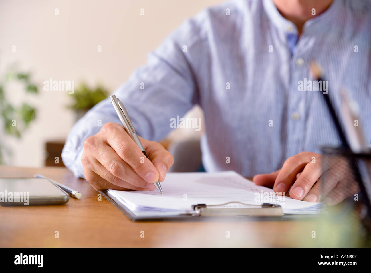 Man filling out a questionnaire on a wooden table. Horizontal ...