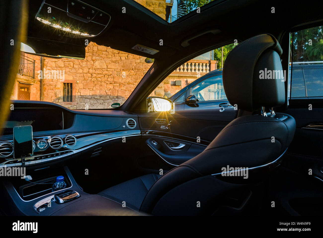 Luxury car interior with sunset lighting and reflections, warm colors ...