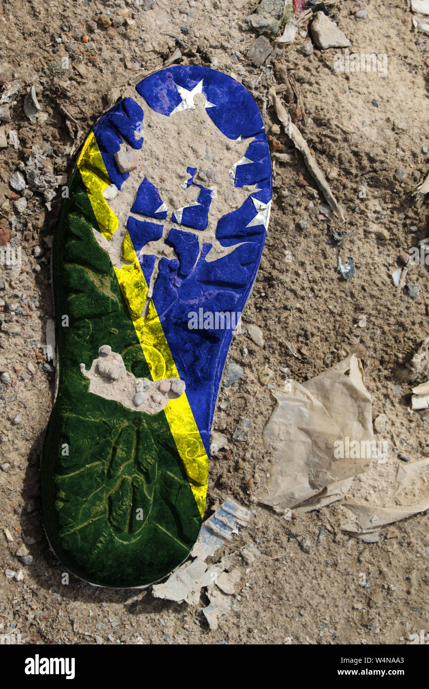 The flag of Solomon Islands is depicted on the sole of an old boot ...
