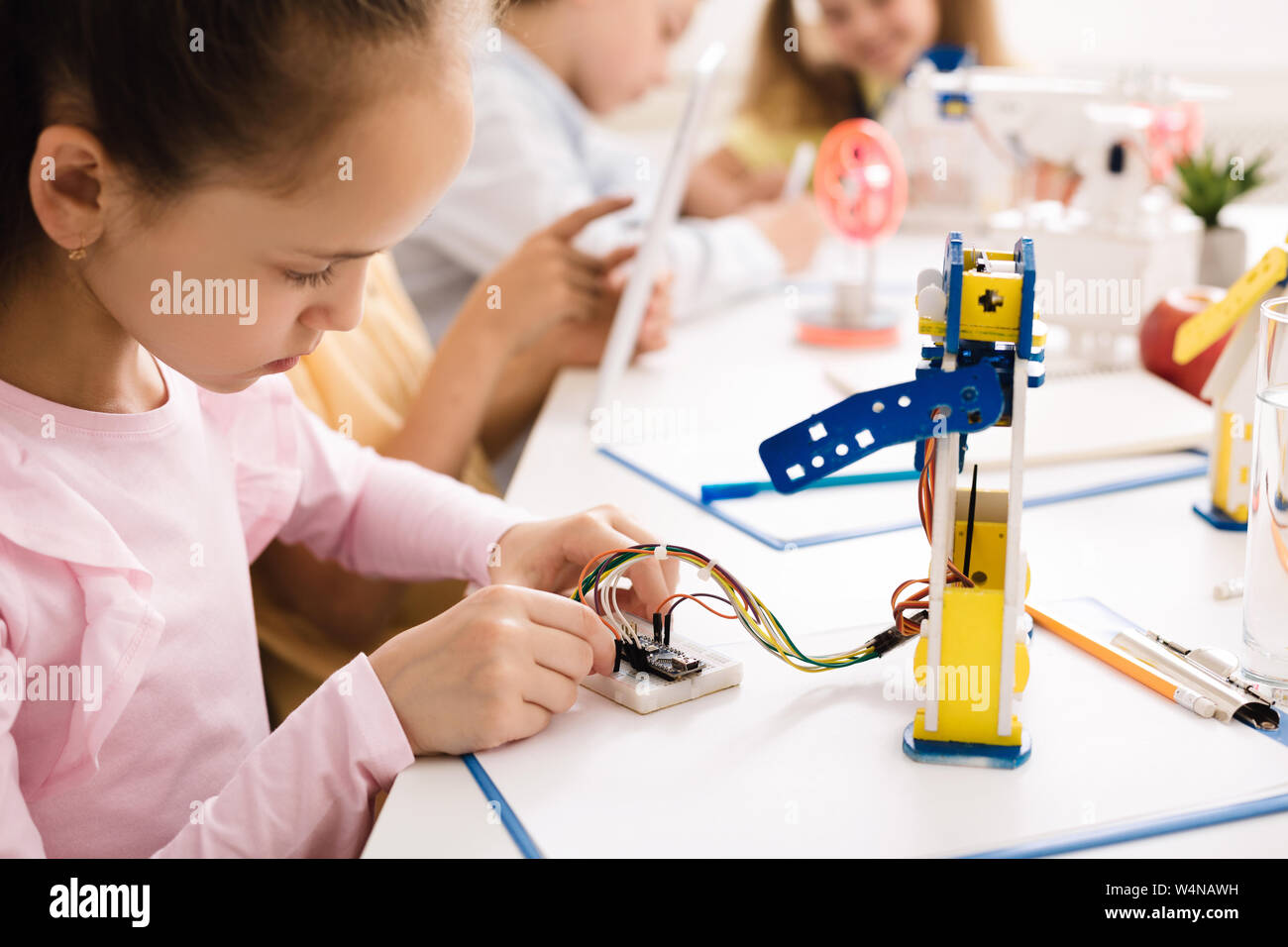 Girl building robot, working with wires in class Stock Photo - Alamy