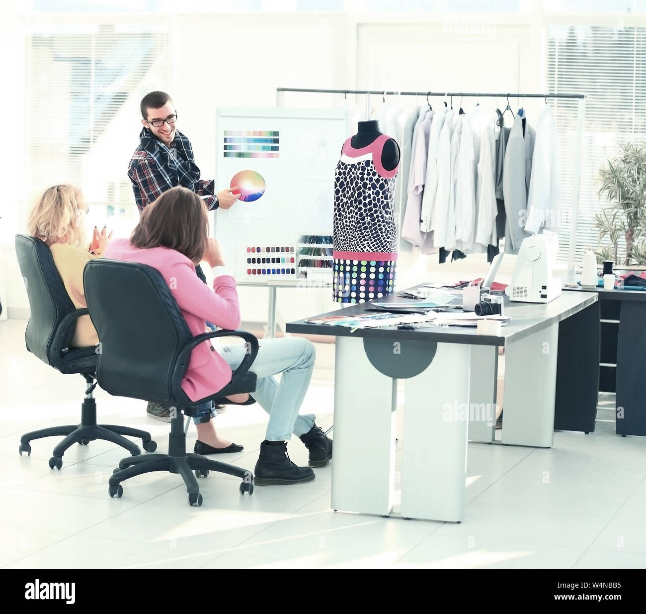 modern designer and his team choose the fabric for clothes in the ...