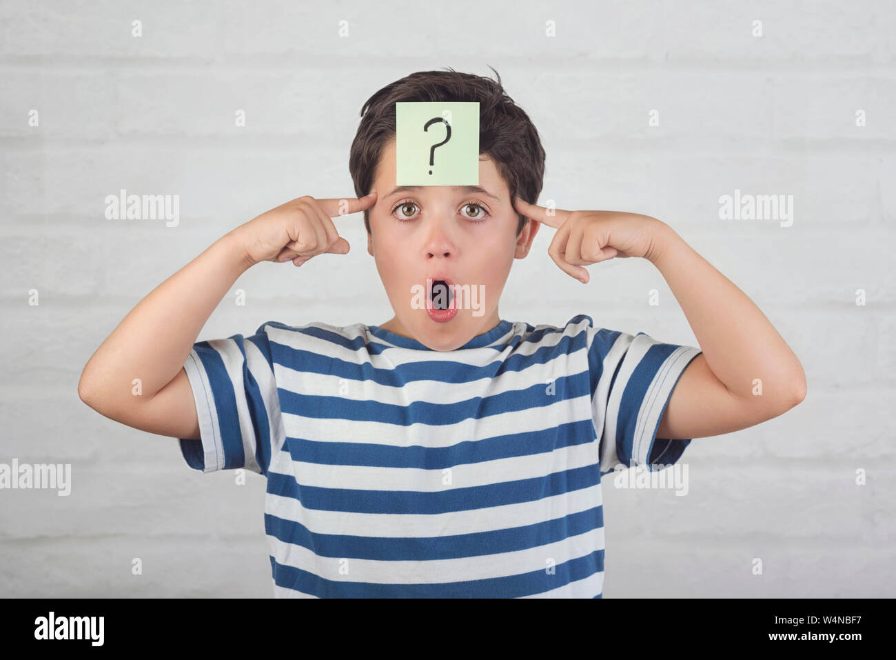 surprised child with question mark in memo post on his forehead over ...