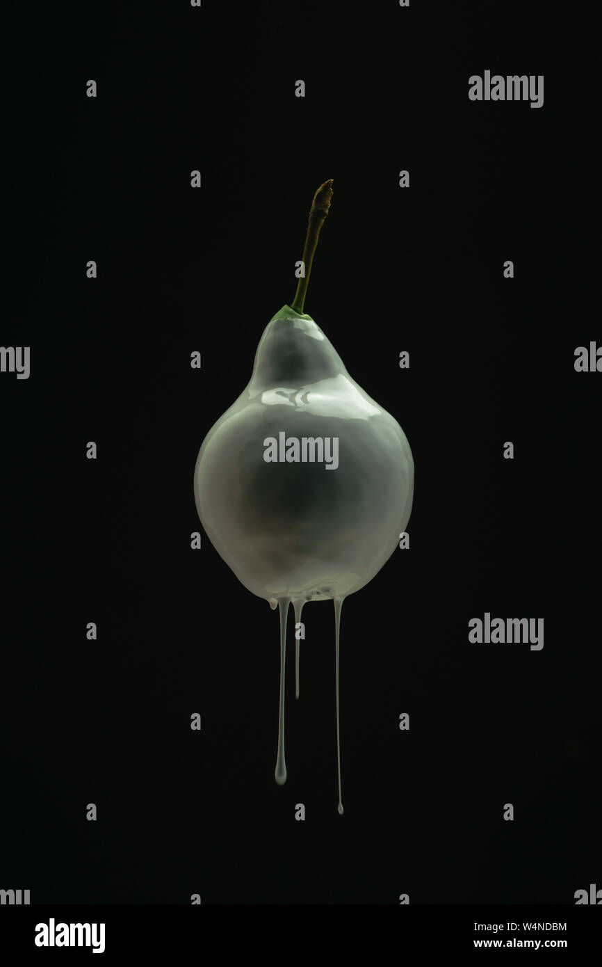 Green Pear dripping white paint on a black background Stock Photo - Alamy