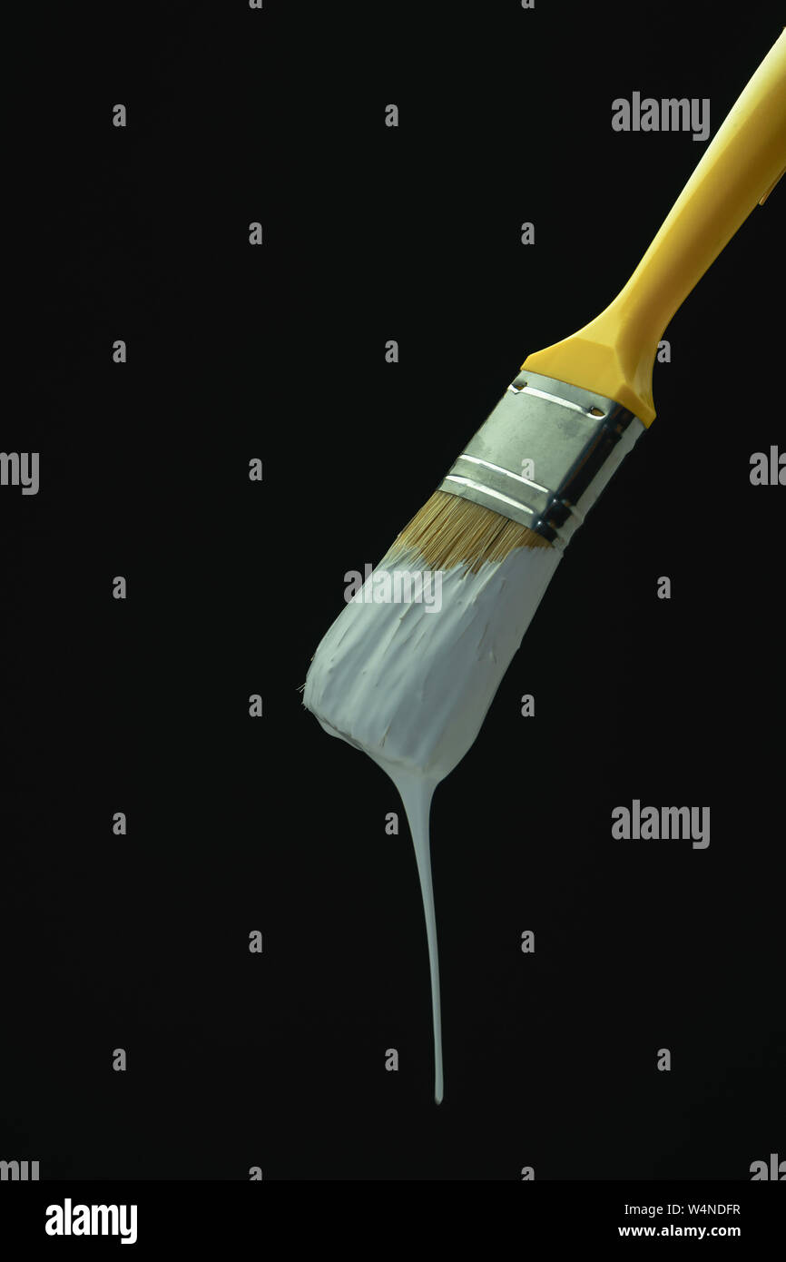 Dripping white paint brush on a blackbackground Stock Photo - Alamy