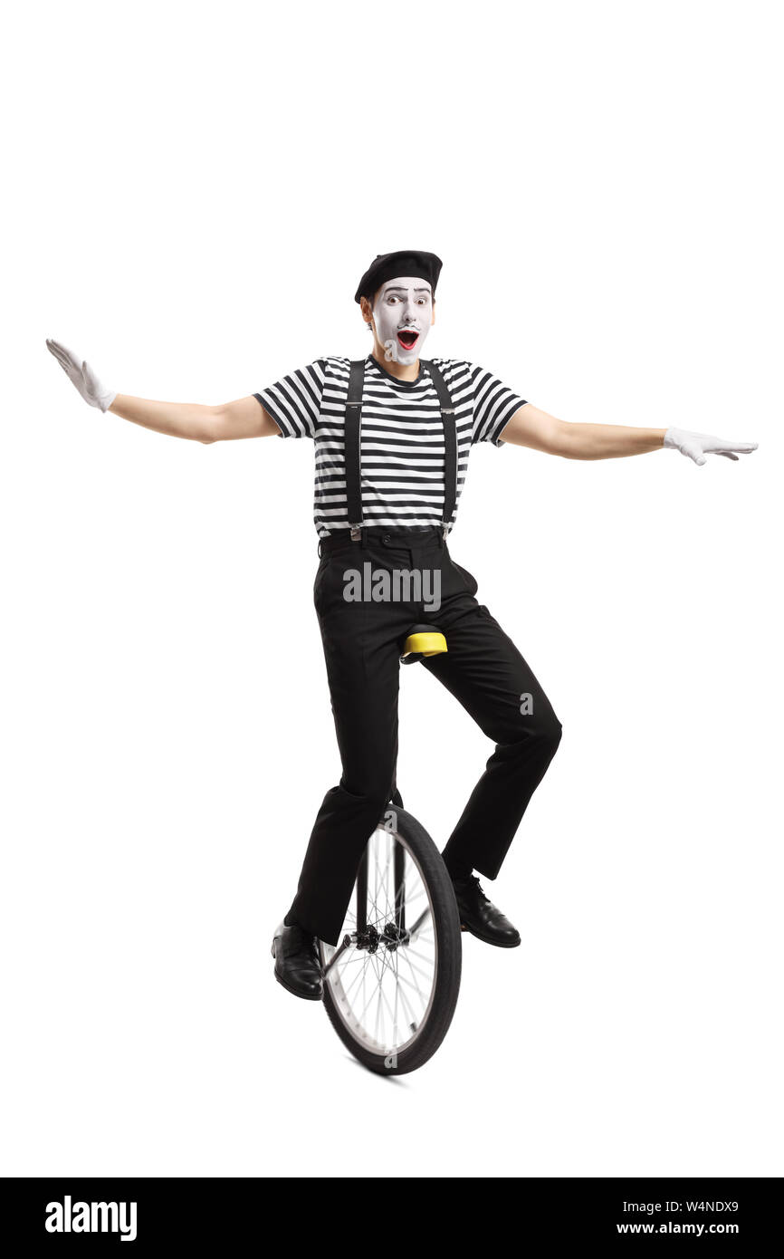 Full length portrait of a mime riding a unicycle and balancing with ...