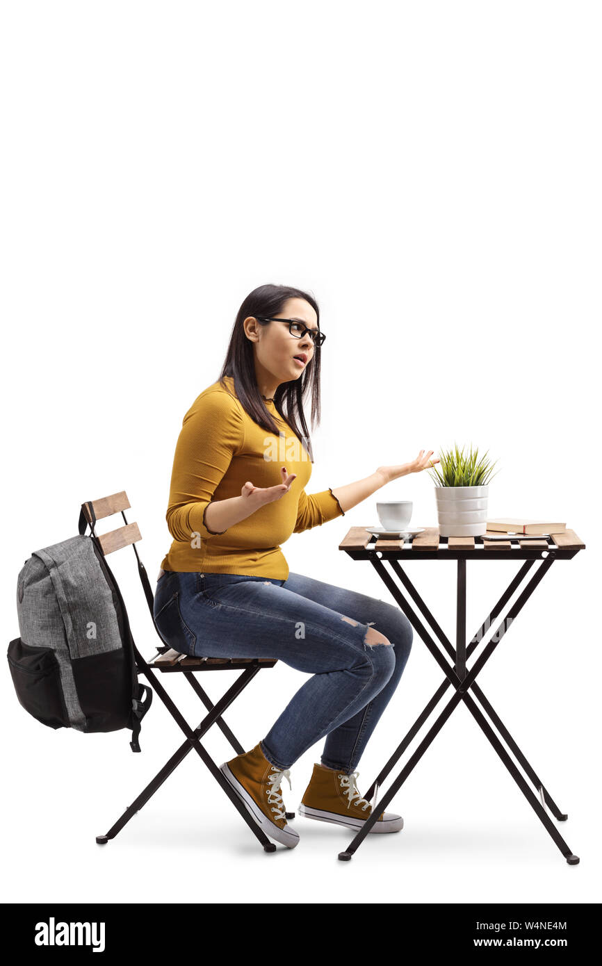 Full length shot of an angry female student in a cafe sitting at a ...