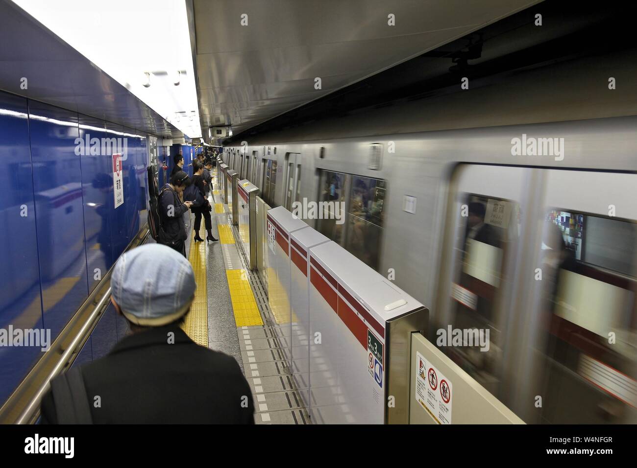 TOKYO, JAPAN - MAY 9, 2012: People wait atTokyo Metro station. With ...