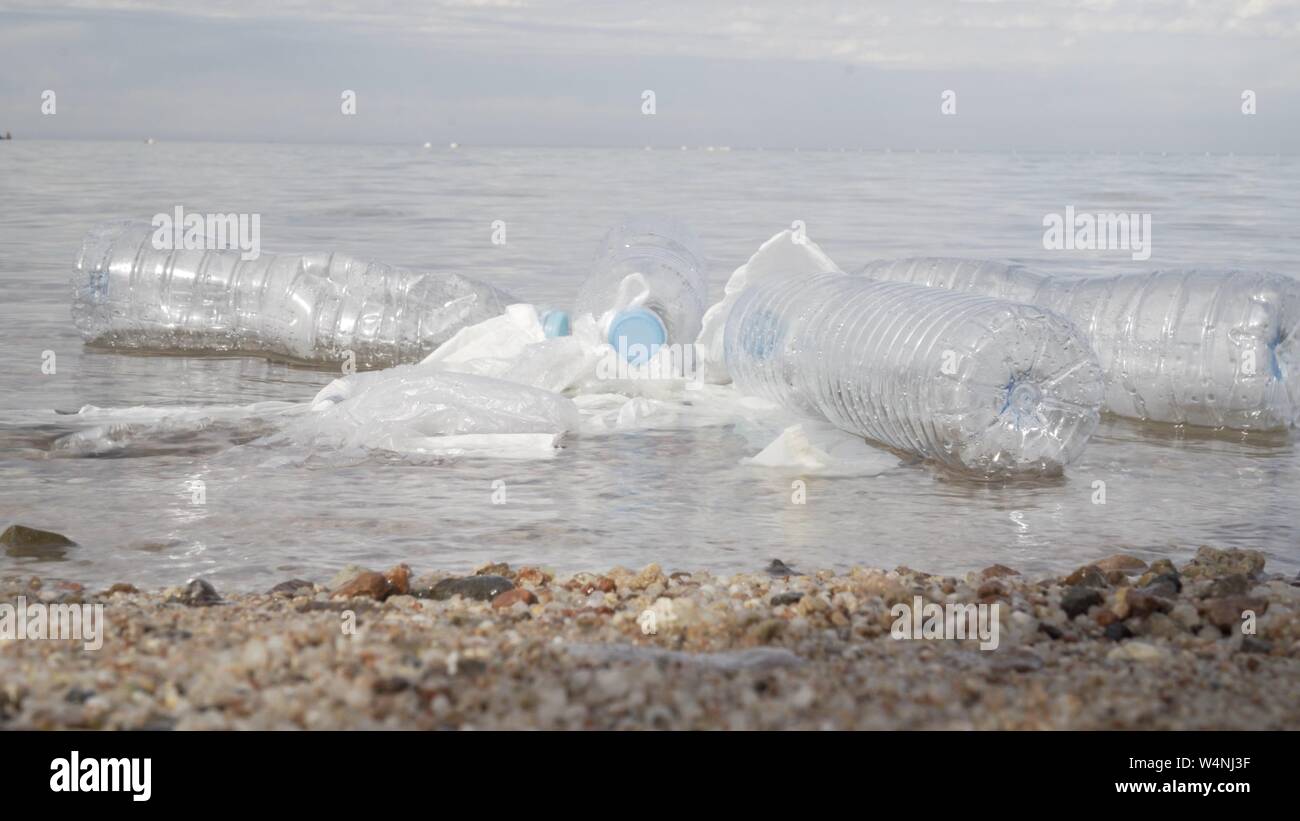 Dirty plastic bottles on the stone beach. Environmental pollution Stock ...