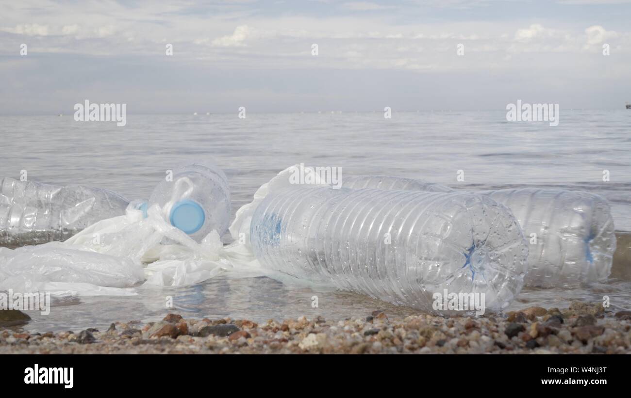 Dirty plastic bottles on the stone beach. Environmental pollution Stock ...