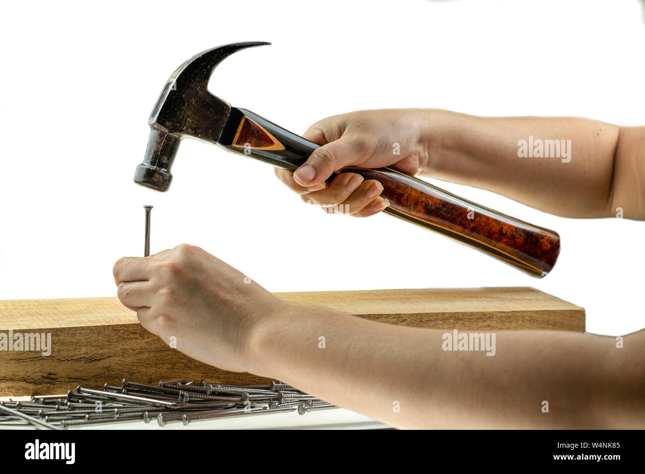 Lady Hand hoiding hammer hitting a nail at white background Stock Photo ...