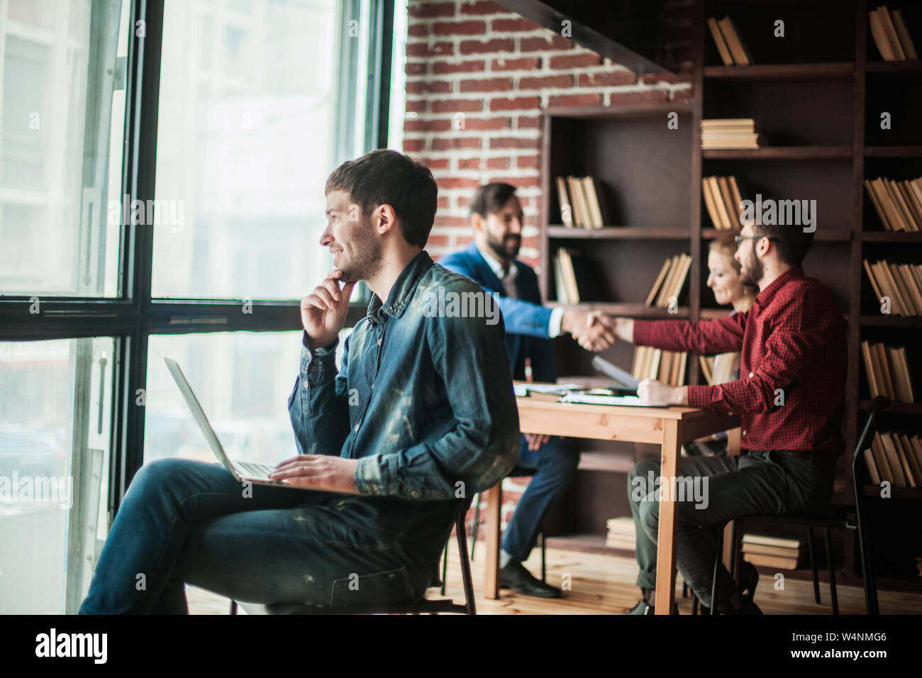 employee of the company with laptop looking out the window on the ...