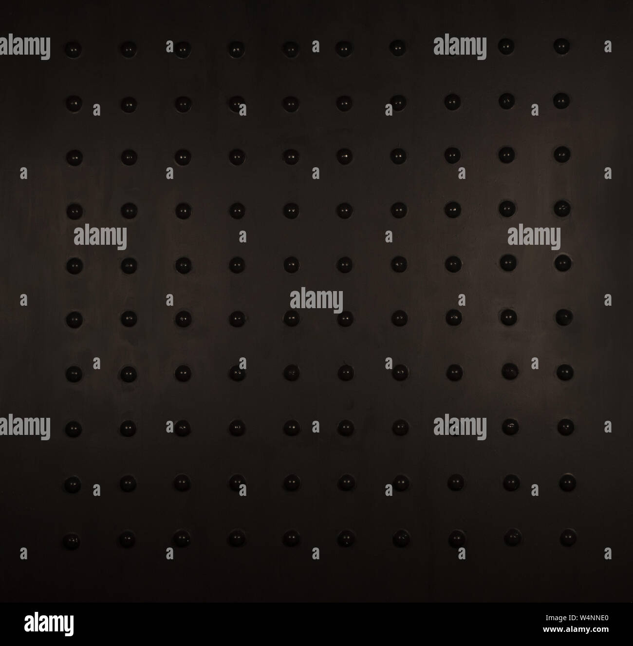 Black background with regularly spaced, shiny black hemispheres ...