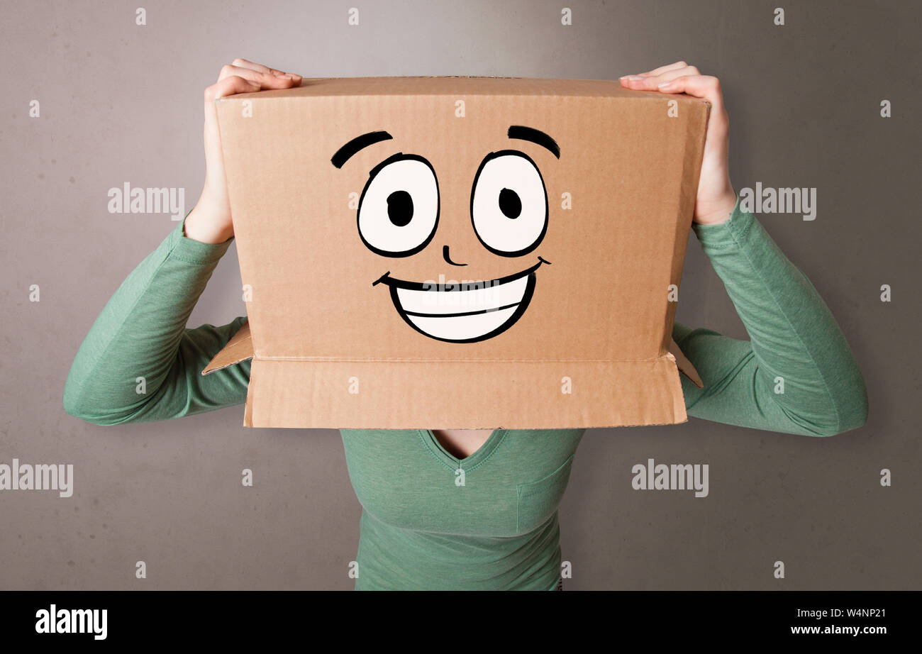 Young girl standing and gesturing with a cardboard box on her head ...